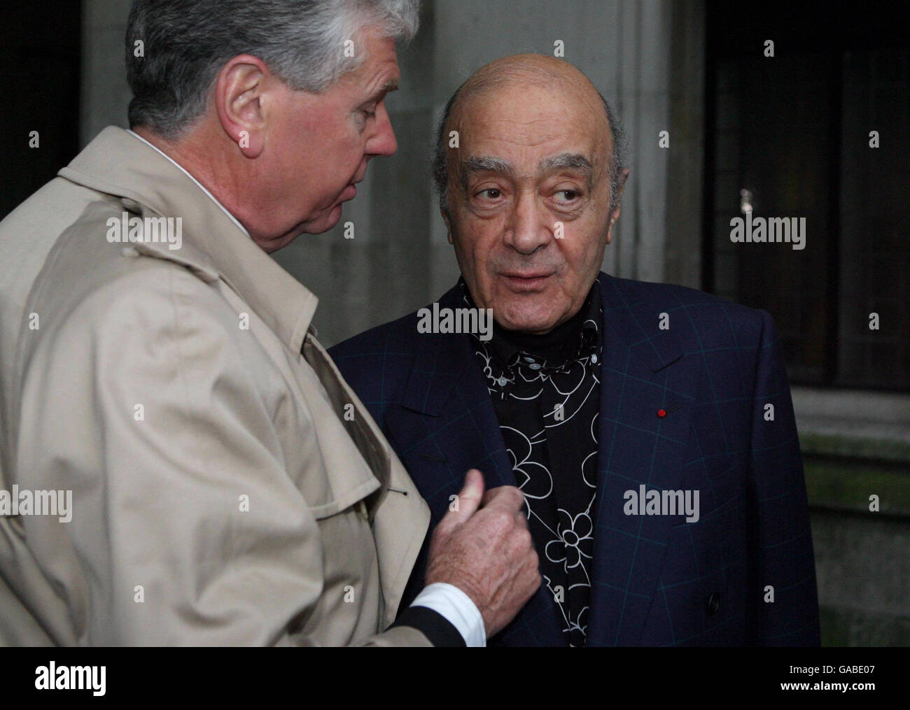 Mohammad Al-fayed talks to an unidentified man as he arrives at the ...