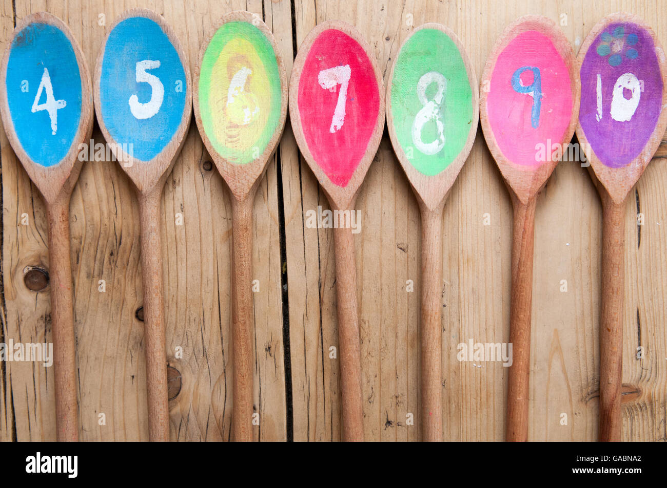 Brightly colored wooden spoons with numbers in a sequence arranged in a ...
