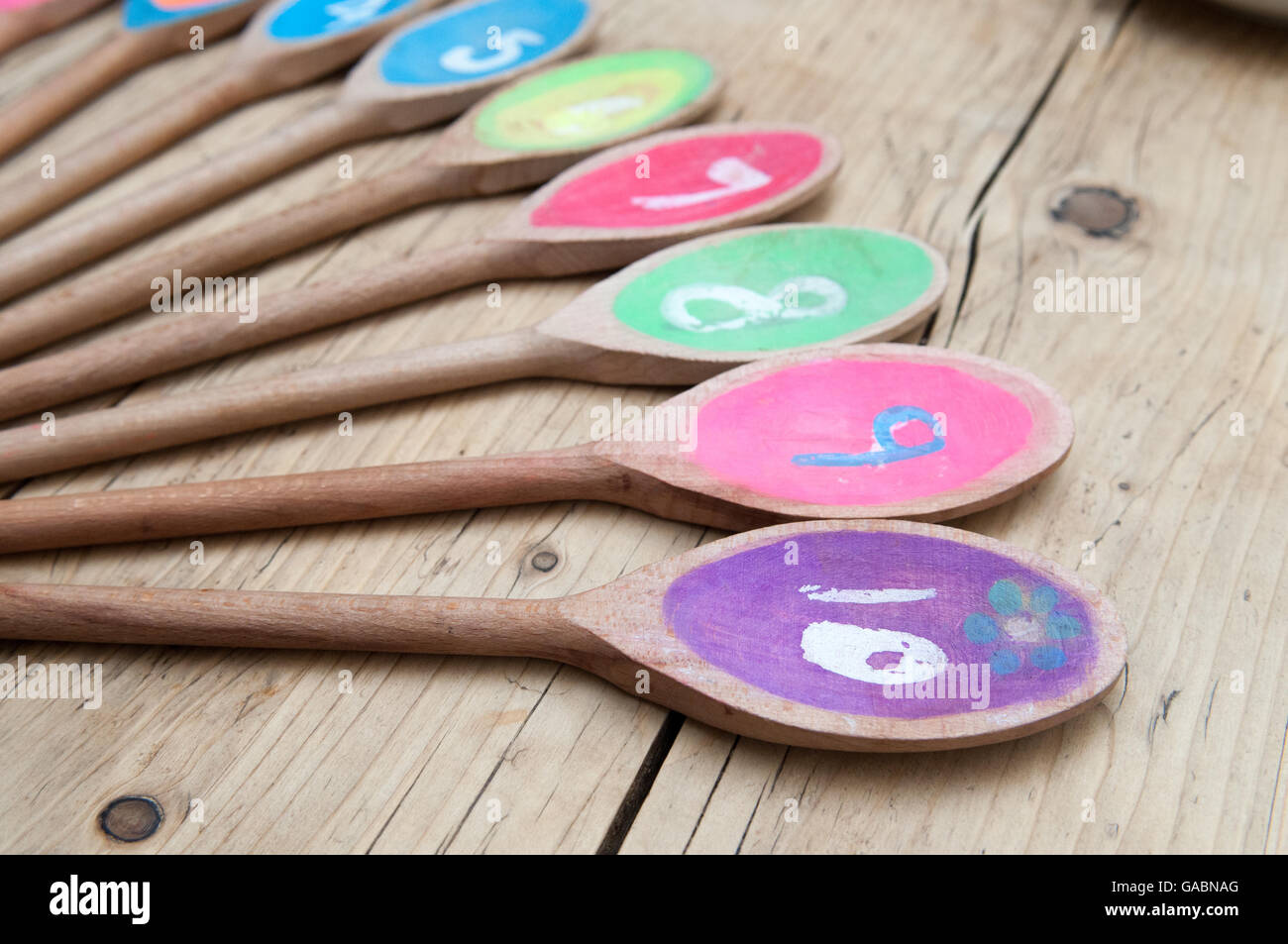 Brightly colored wooden spoons with numbers in a sequence arranged in a ...