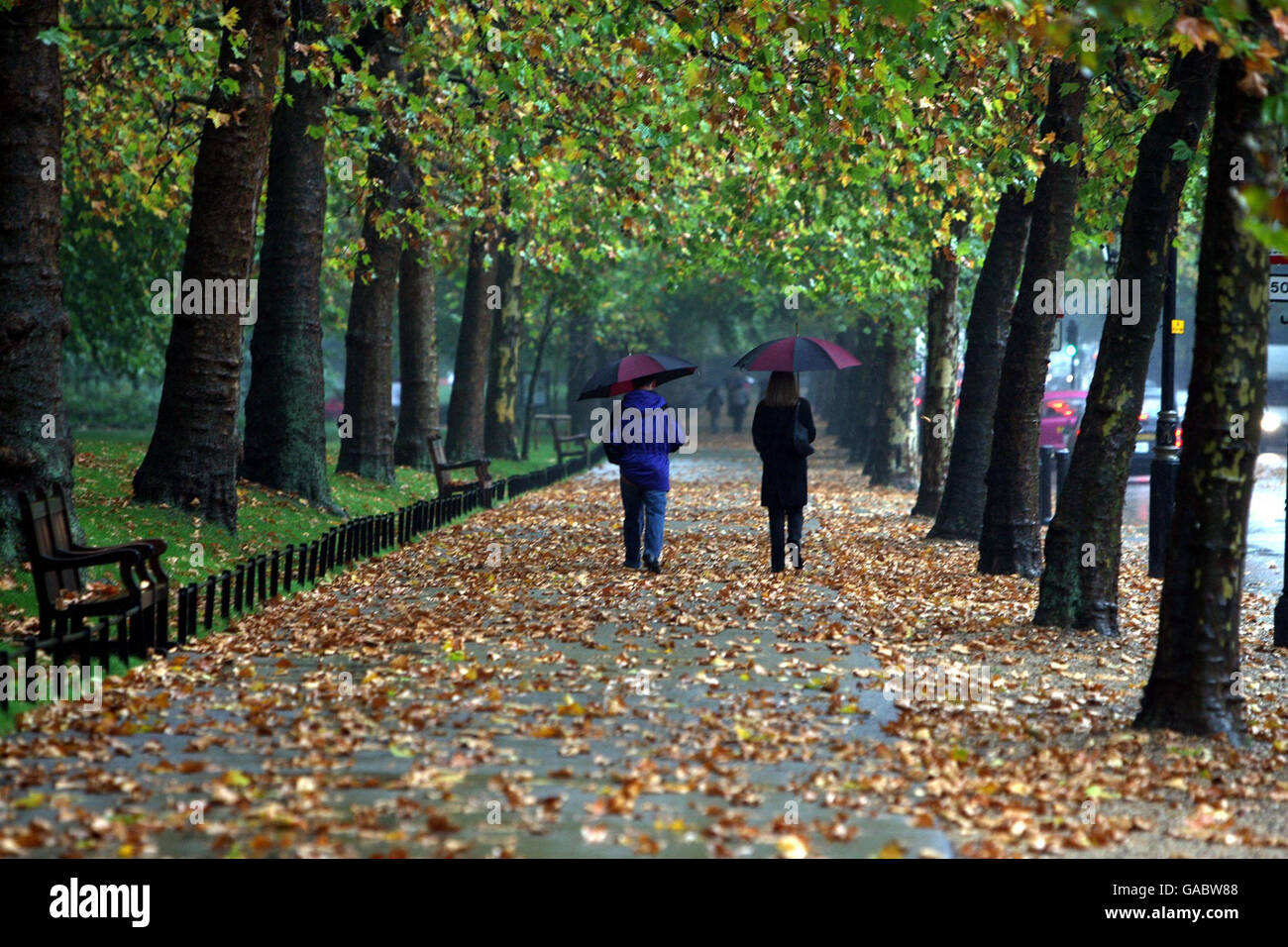 People walk through the rain with umbrellas near St James's Park ...