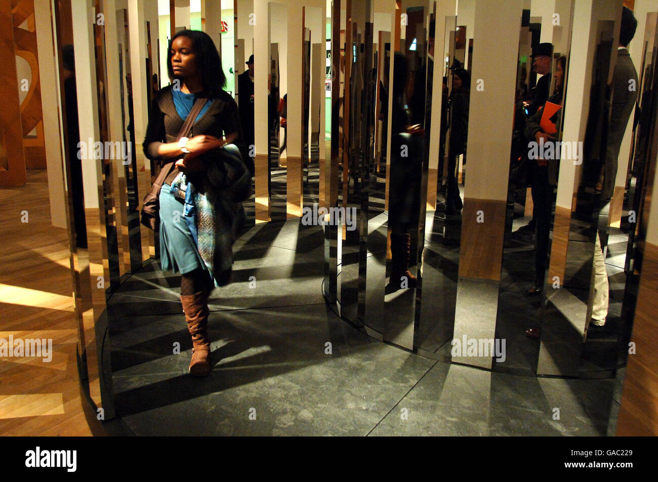 A woman walks through a mirror labyrinth entitled Rotating Labyrinth ...