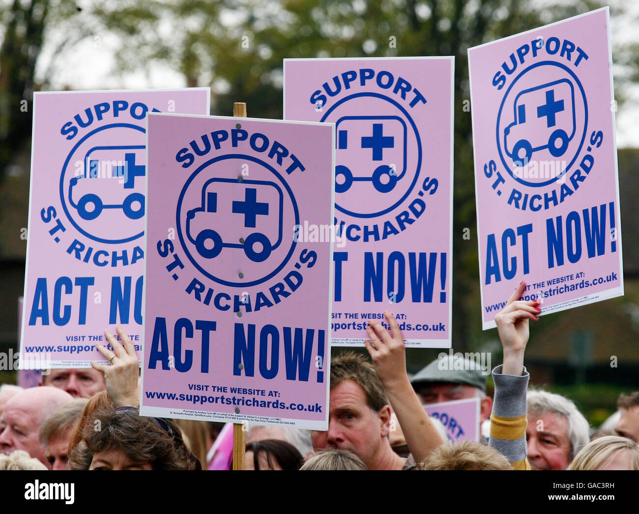 Demonstrators hold placards during a rally in Priory Park Chichester ...