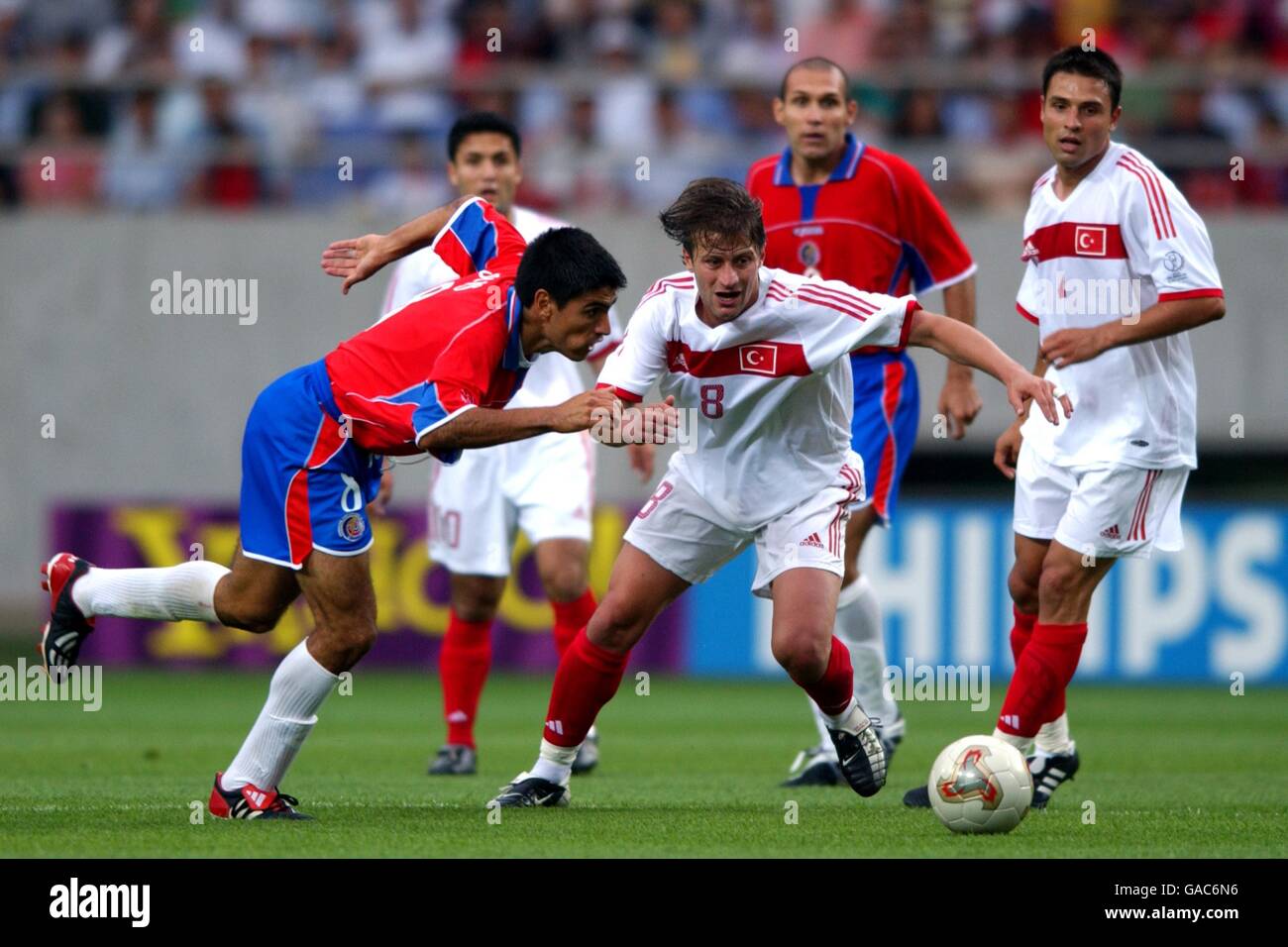 Costa Rica's Mauricio Solis and Turkey's Tugay Kerimoglu chase the ball ...