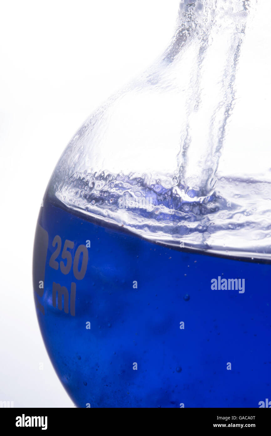 blue chemistry pouring into boiling flask Stock Photo - Alamy
