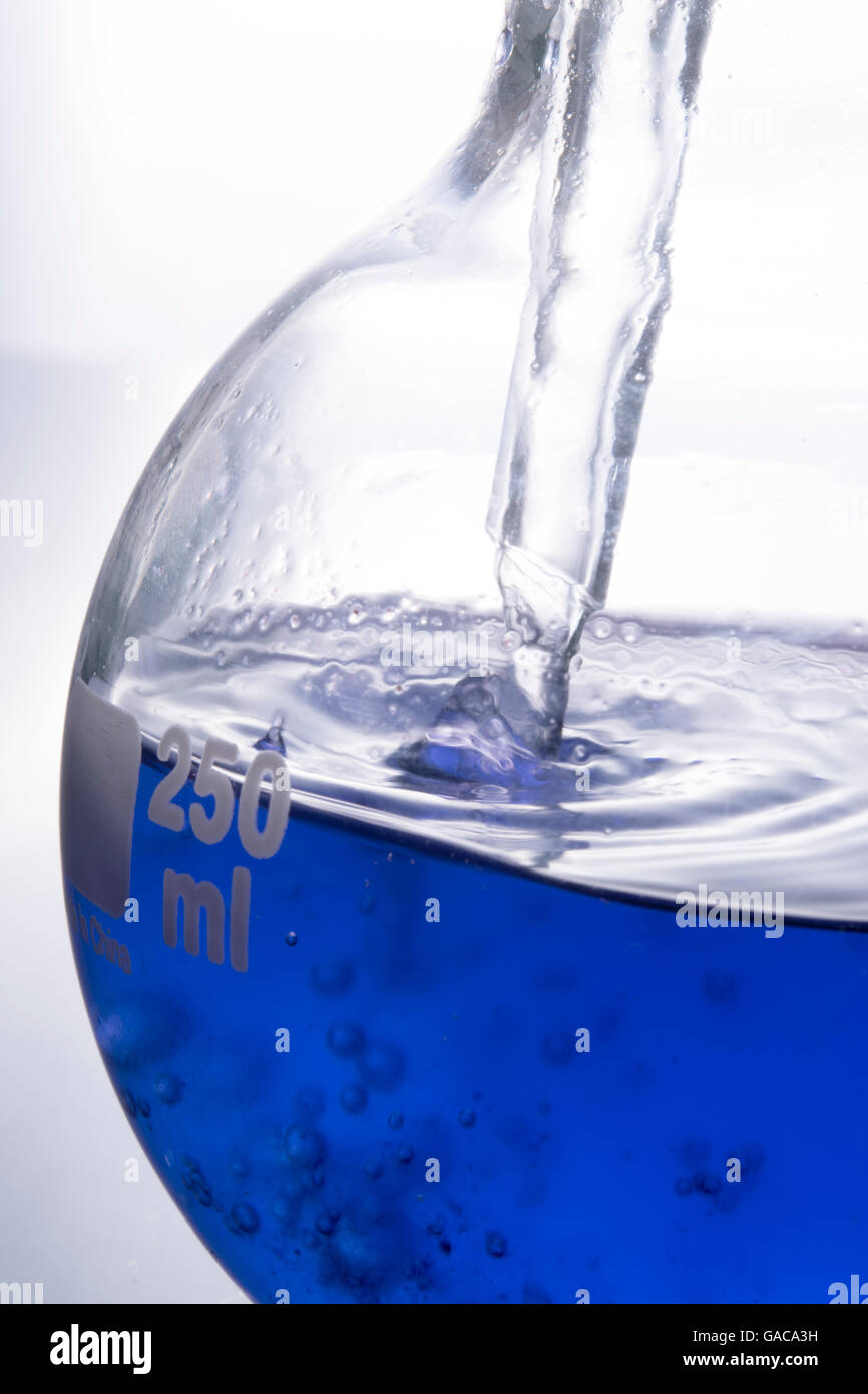 blue chemistry pouring into boiling flask Stock Photo - Alamy