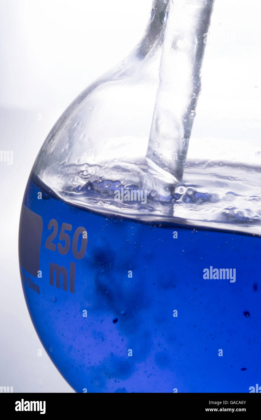 blue chemistry pouring into boiling flask Stock Photo - Alamy