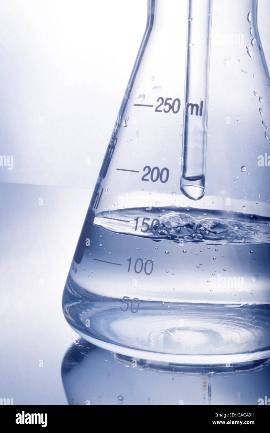 chemistry pouring into flask, monochrome Stock Photo - Alamy