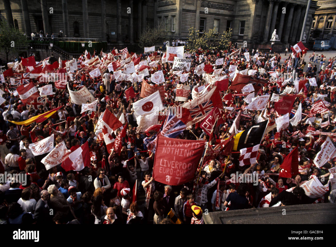 The flag waving crowd welcoming the Liverpool FC team on their return ...