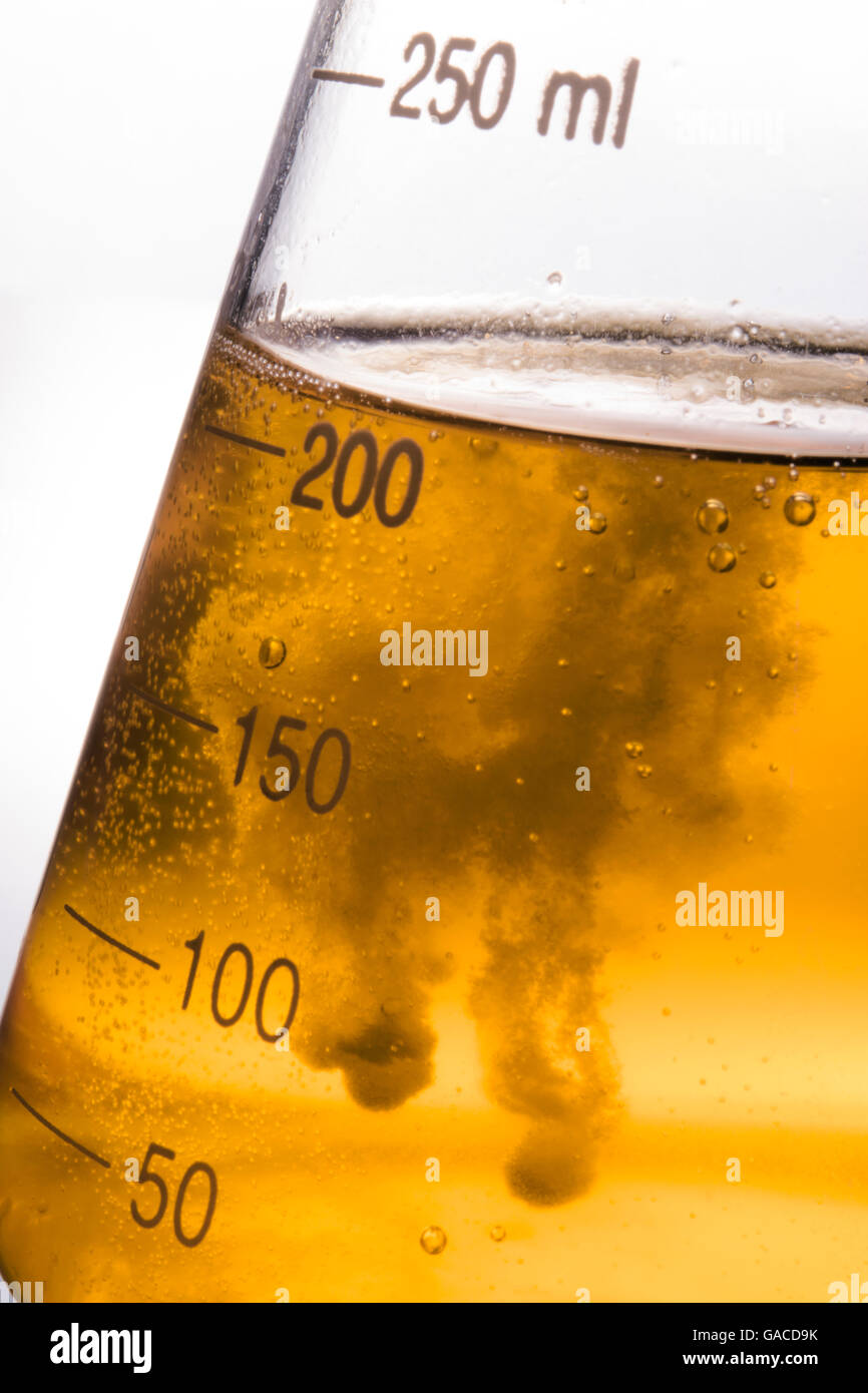 Orange chemical reaction in flask Stock Photo - Alamy