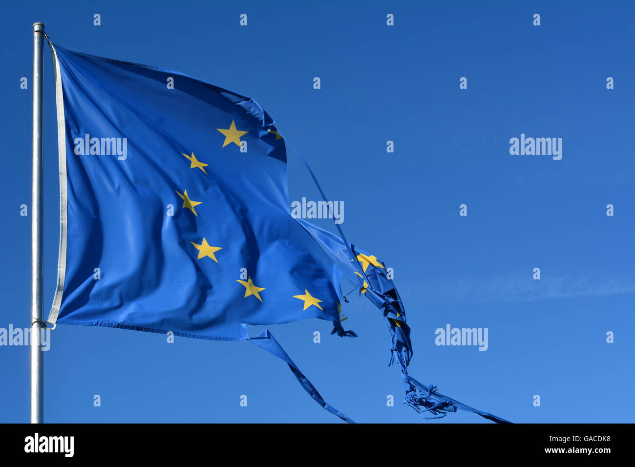 The european union twelve star flag torn and with knots in the wind on ...