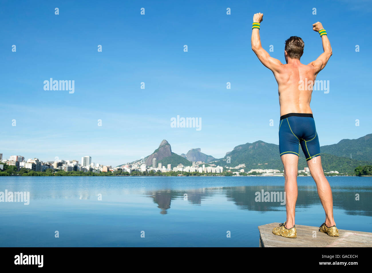 Athlete in blue compression shorts standing with champion arms raised ...