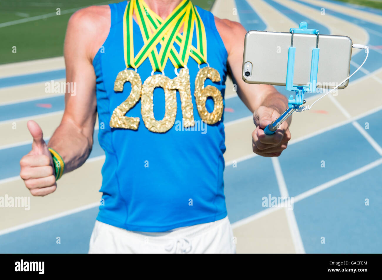 Athlete standing at the running track taking a selfie on his mobile ...