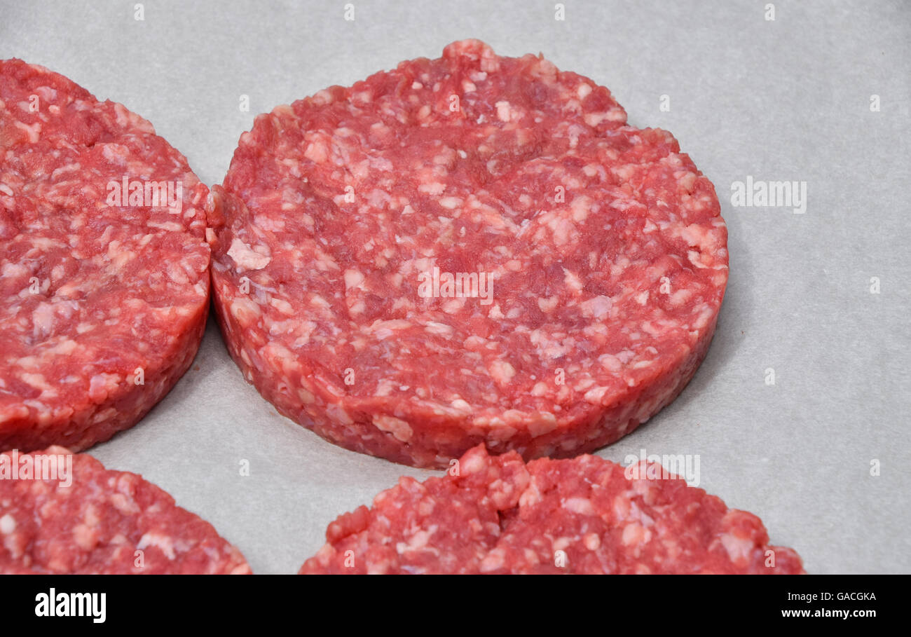 Raw red meat burgers for hamburgers of minced ground beef or pork on ...