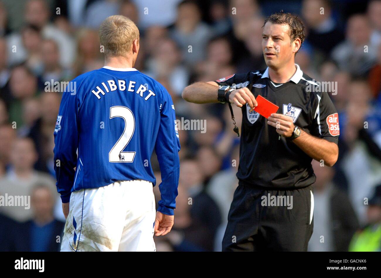 Referee Mark Clattenburg (right) shows Everton's Tony Hibbert the red ...