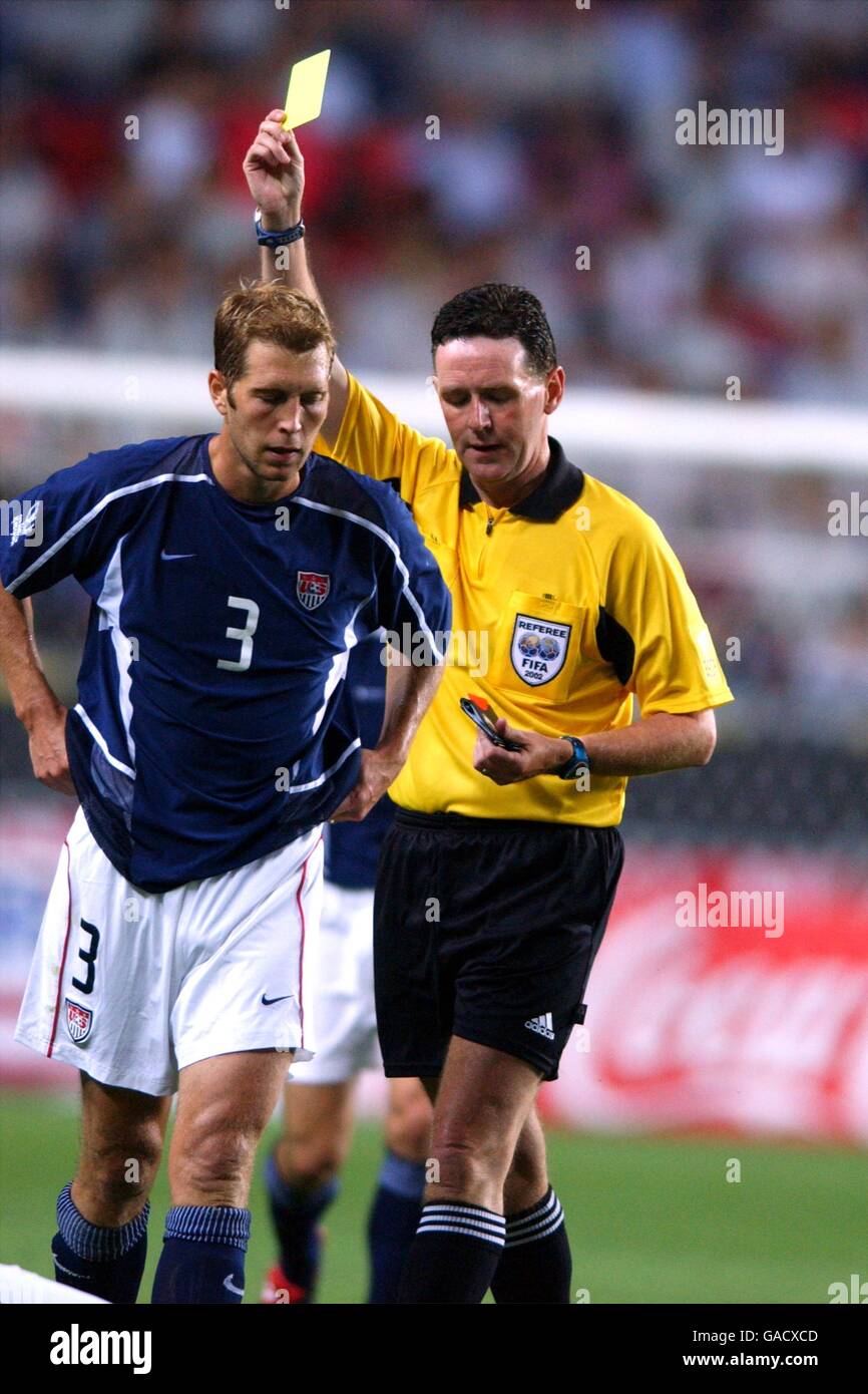 USA's Gregg Berhalter is shown the yellow card by referee Hugh Dallas ...