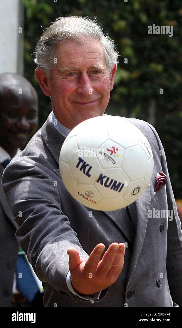 Prince Charles passes a football to Ugandan children at the Kampala ...