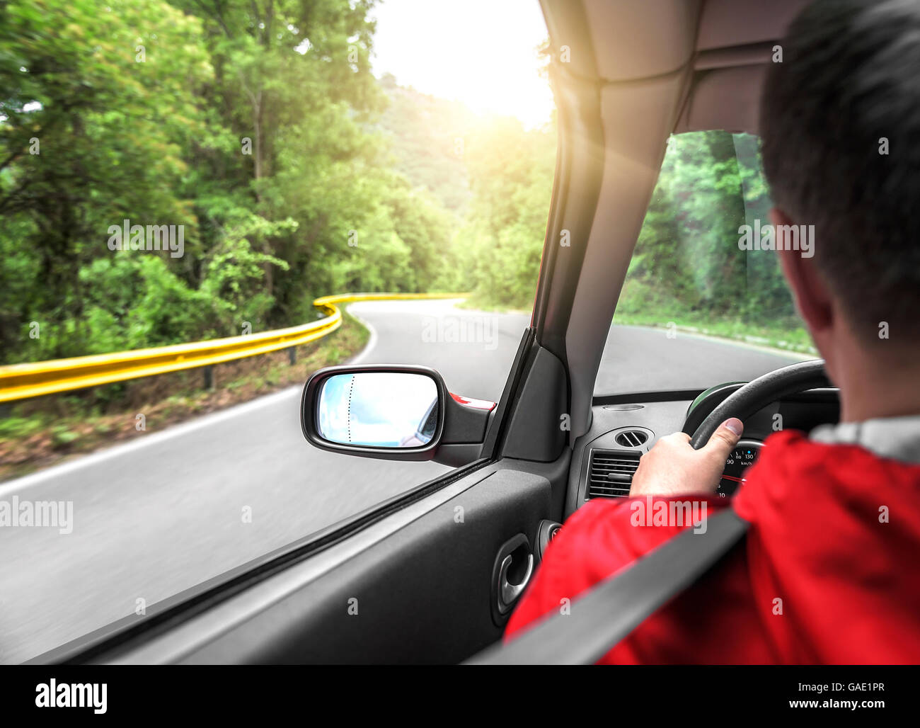 Male driver drives a convertible car on the country road. The view from ...