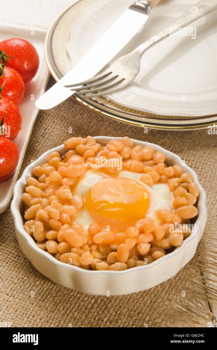 baked beans with fried egg in a round, small serving plate Stock Photo ...