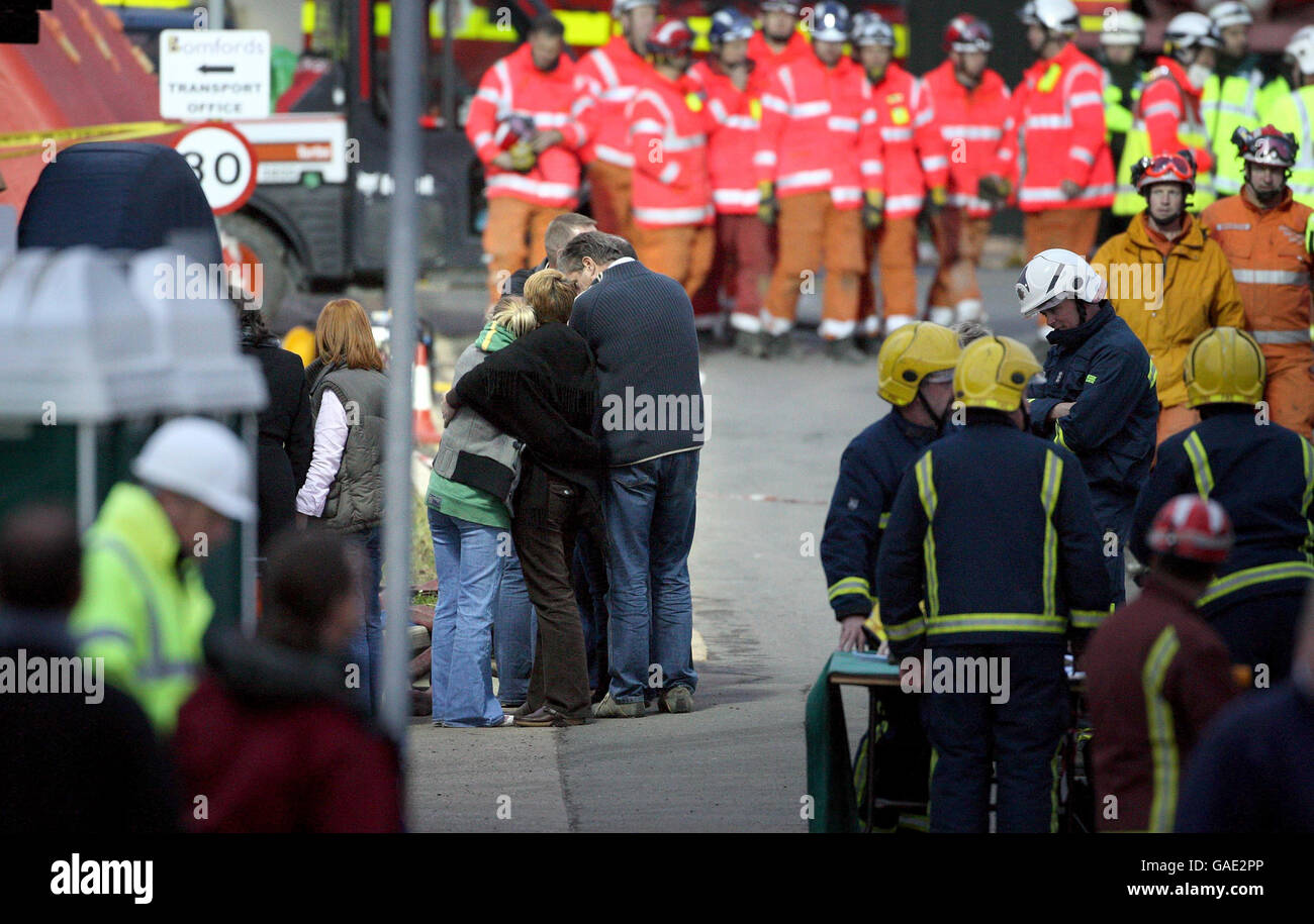 Relatives of the missing firefighters comfort each other as the search ...