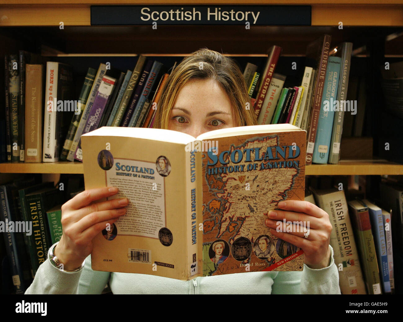 PICTURE POSED BY MODEL. A unnamed person reads a Scottish history book ...