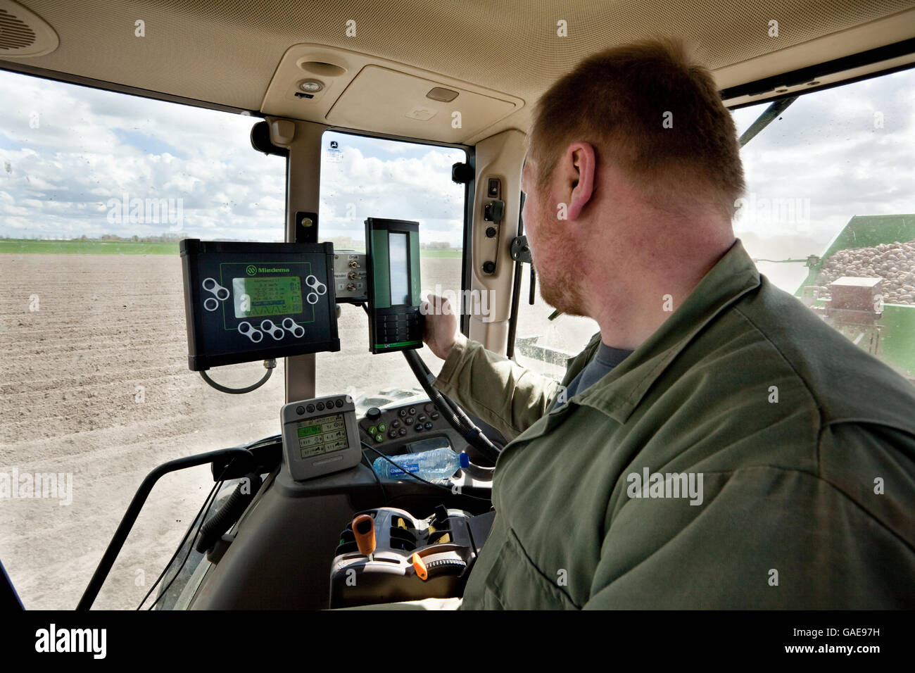 Farmer driving tractor and using computer on the field Stock Photo - Alamy