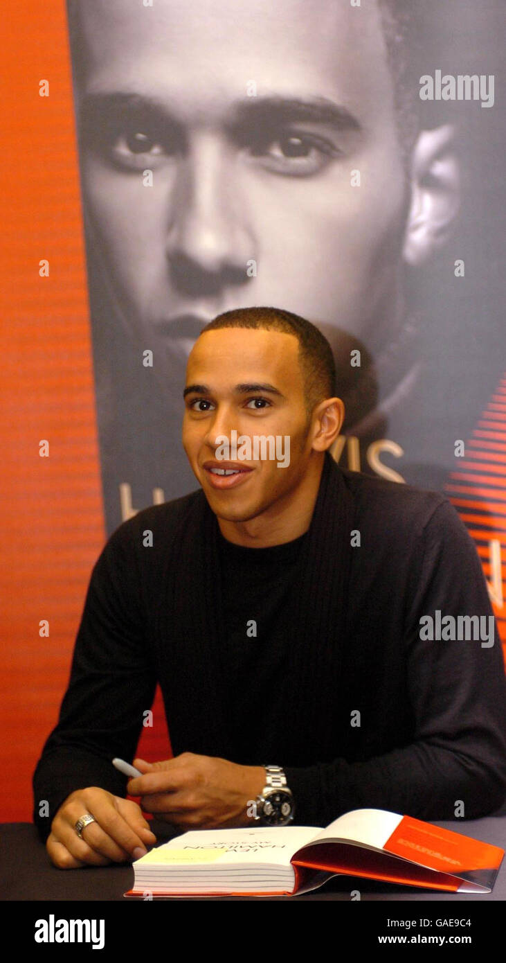 Formula 1 racing driver Lewis Hamilton signs copies of his ...