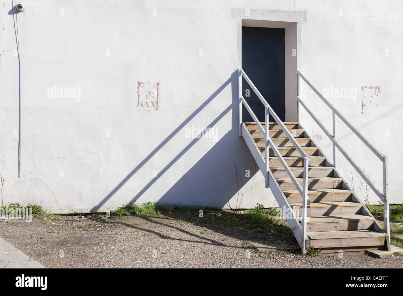 Wooden staircase casting a shadow on a wall Stock Photo - Alamy