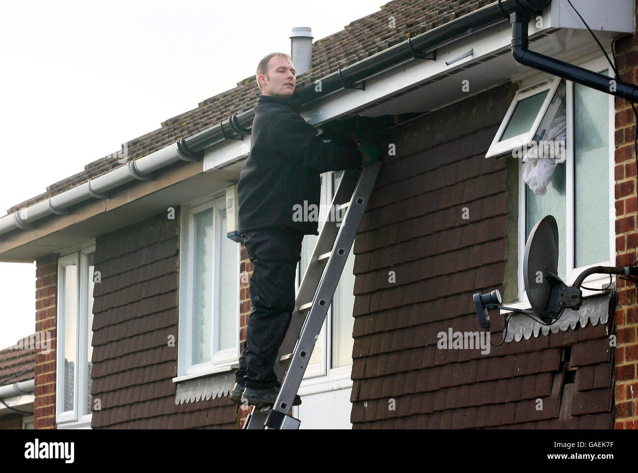 A police officer searches the front of the house at the former home of ...