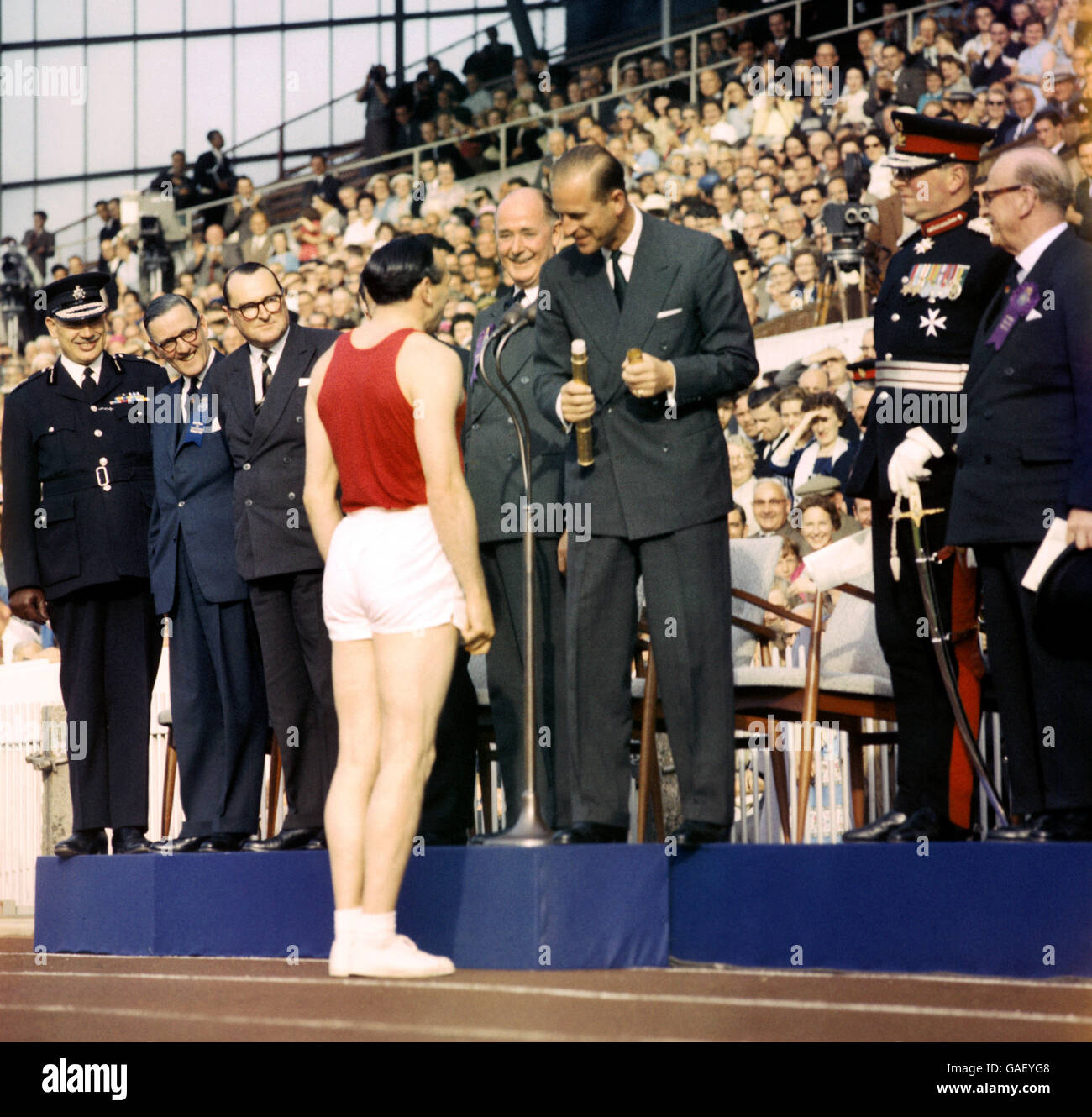 Welsh athlete and rugby player Ken Jones handing a baton from the Queen ...