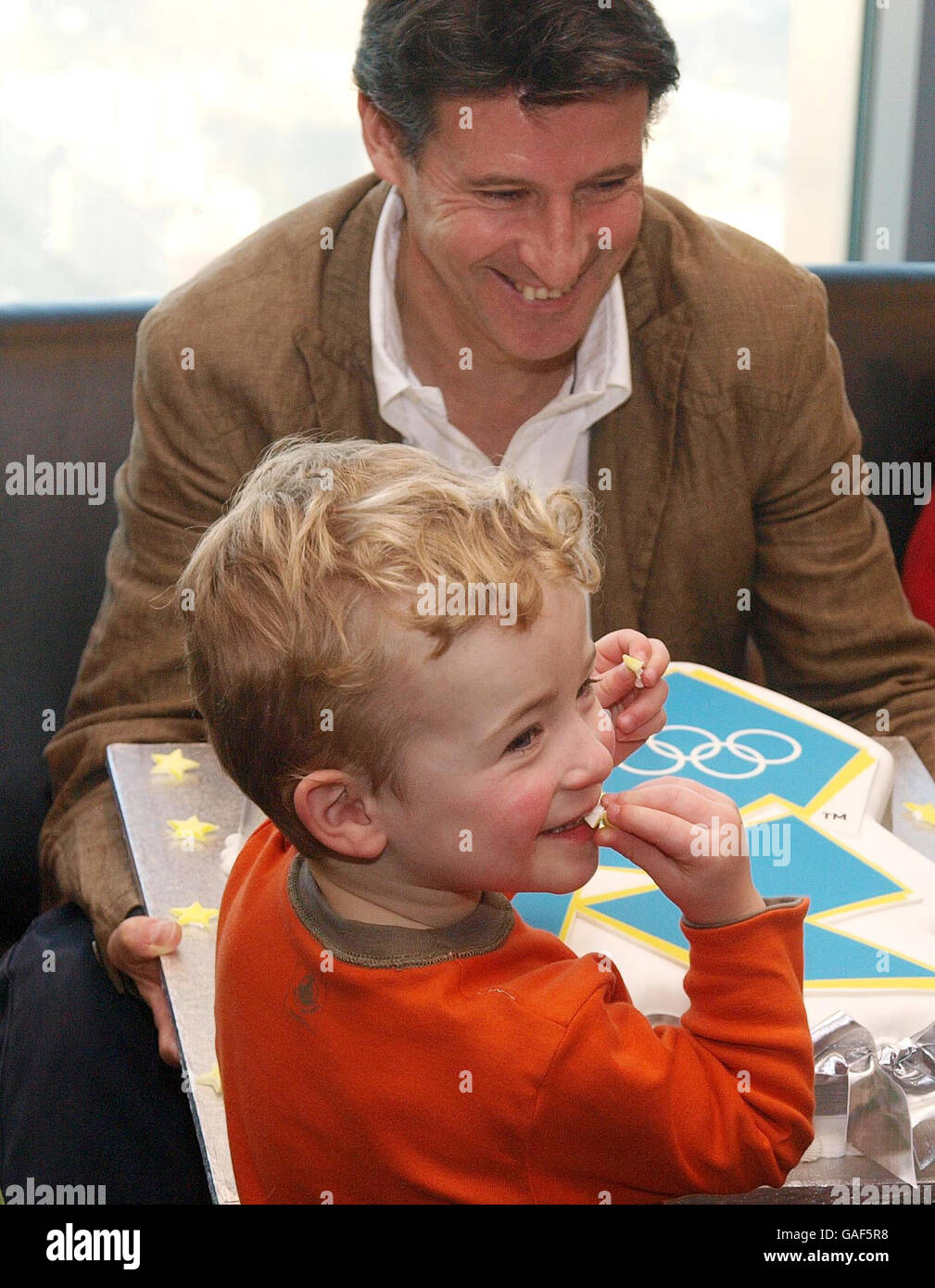 Lord Coe watches as William Talbot uninvitedly helps himself to a piece ...