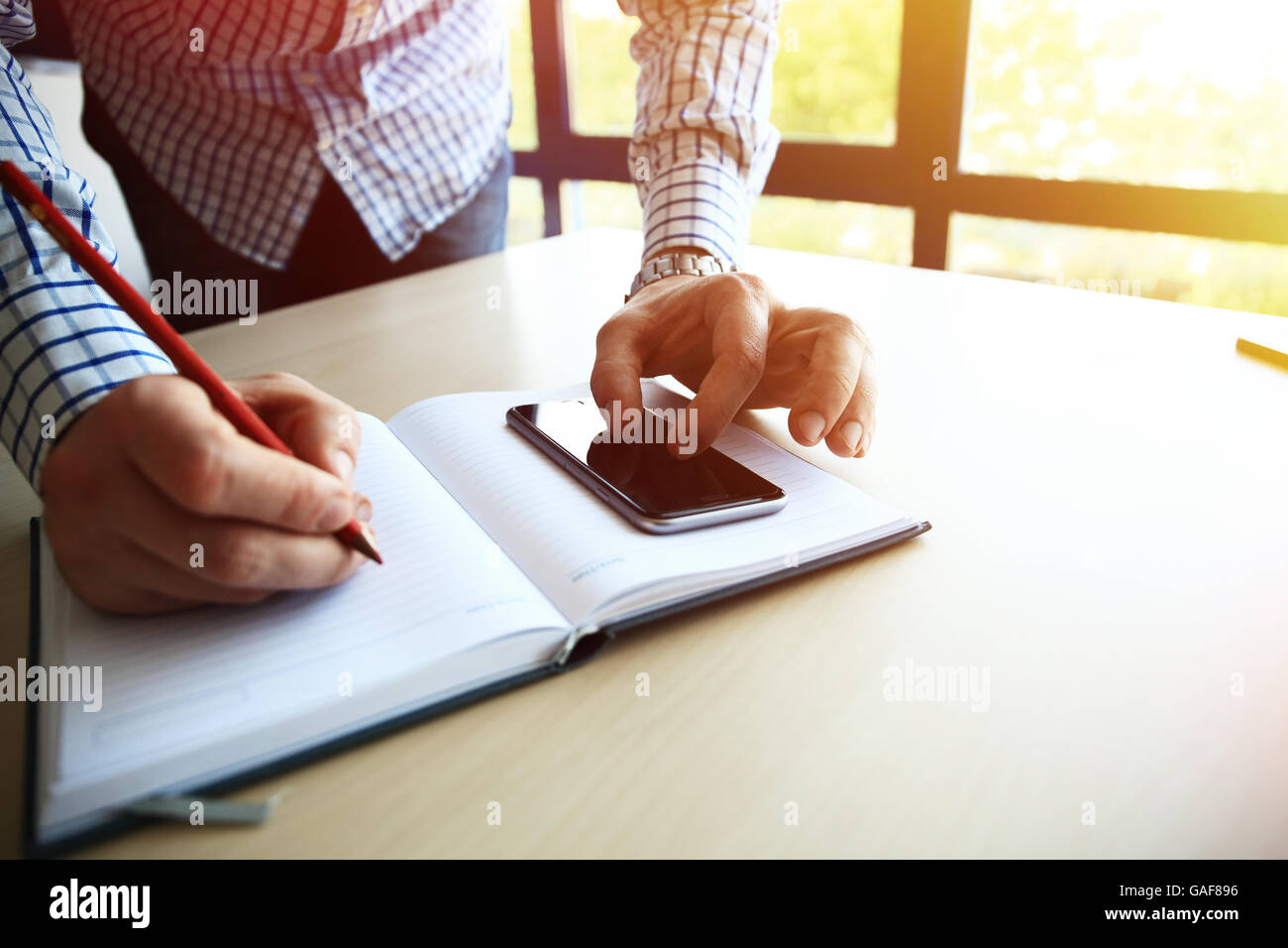 Male hand holding pencil ready to make note in opened notebook while ...