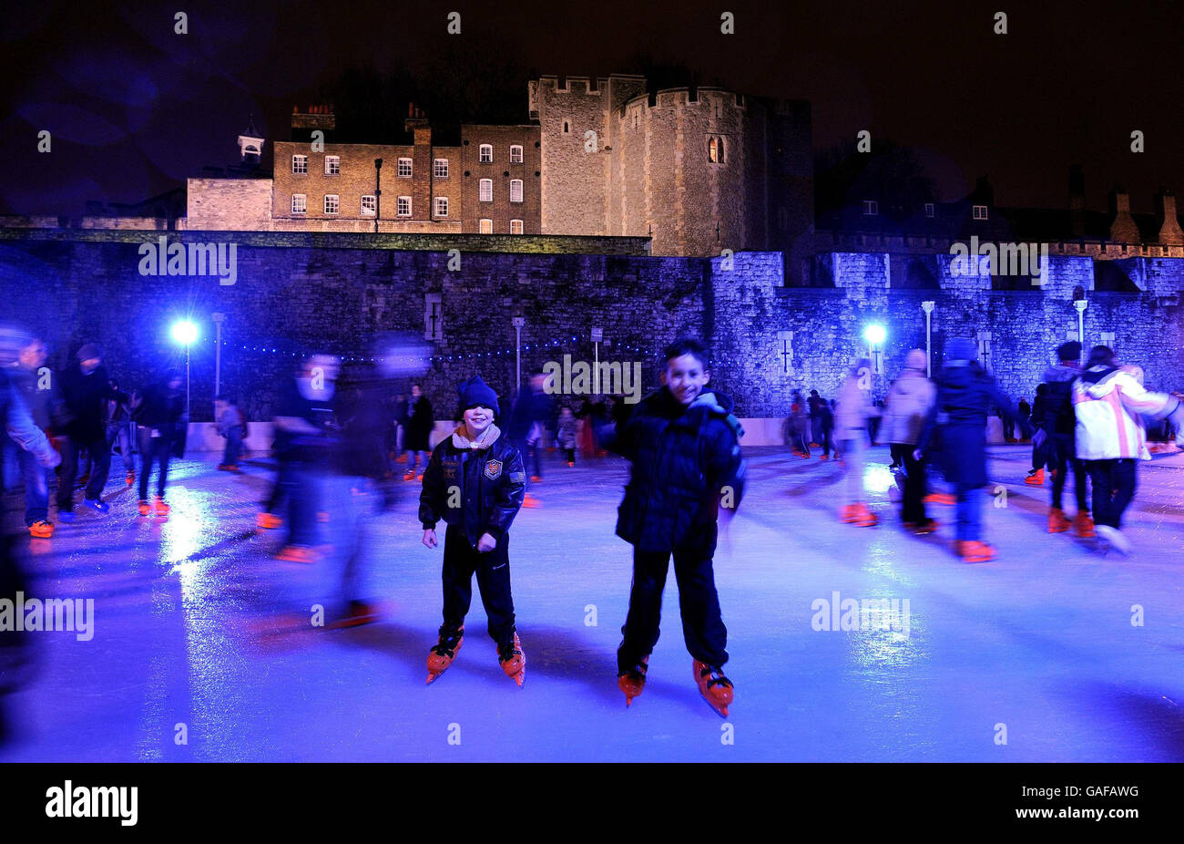 A pair of young boys enjoy the ice-skating in the moat of the Tower of ...