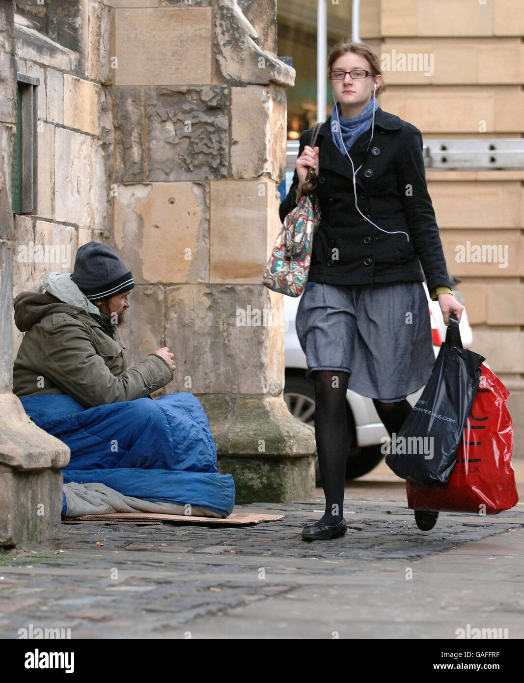 A shopper passes by a homeless man in York City centre today while out ...