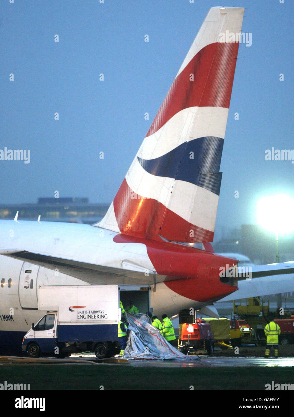 Workers remove the emergency slides from the British Airways 777 that ...