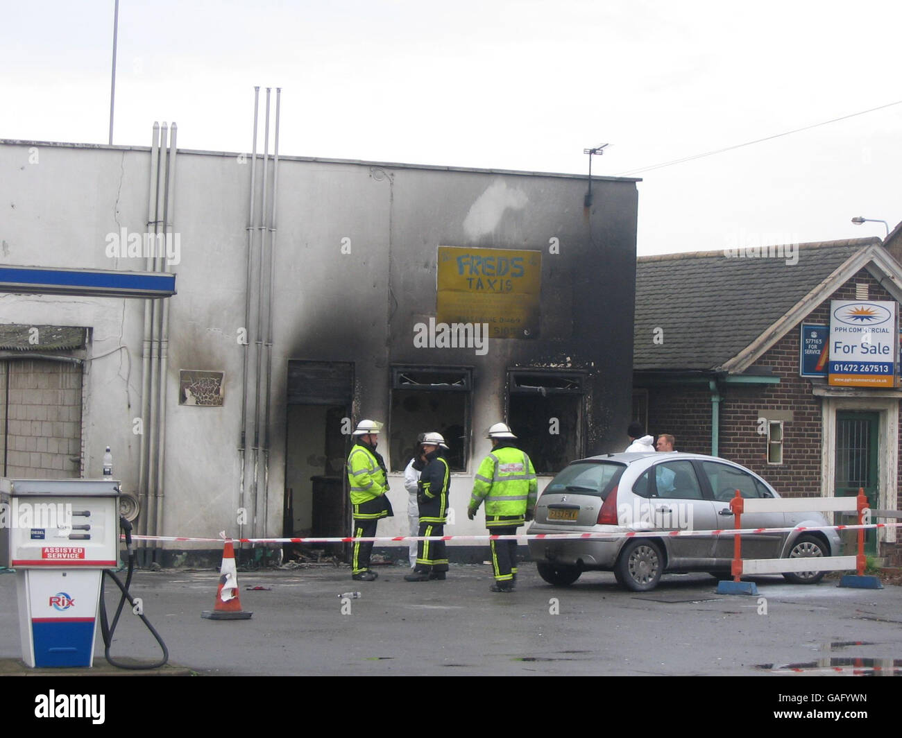 Firefighters at the scene of a fire which killed two people at a taxi ...