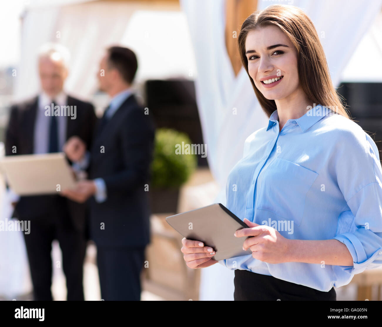 Positive woman holding tablet Stock Photo - Alamy