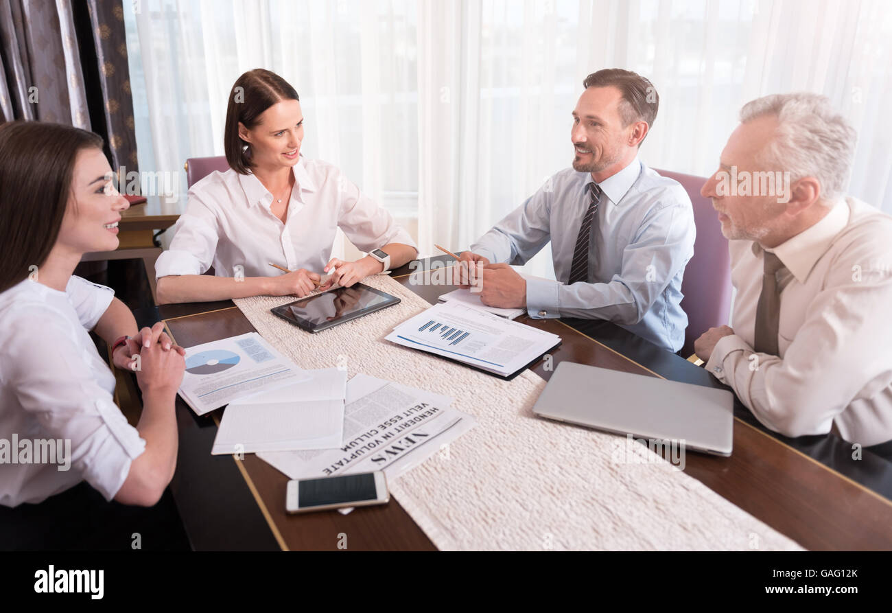 Cheerful colleagues sitting at the table Stock Photo - Alamy