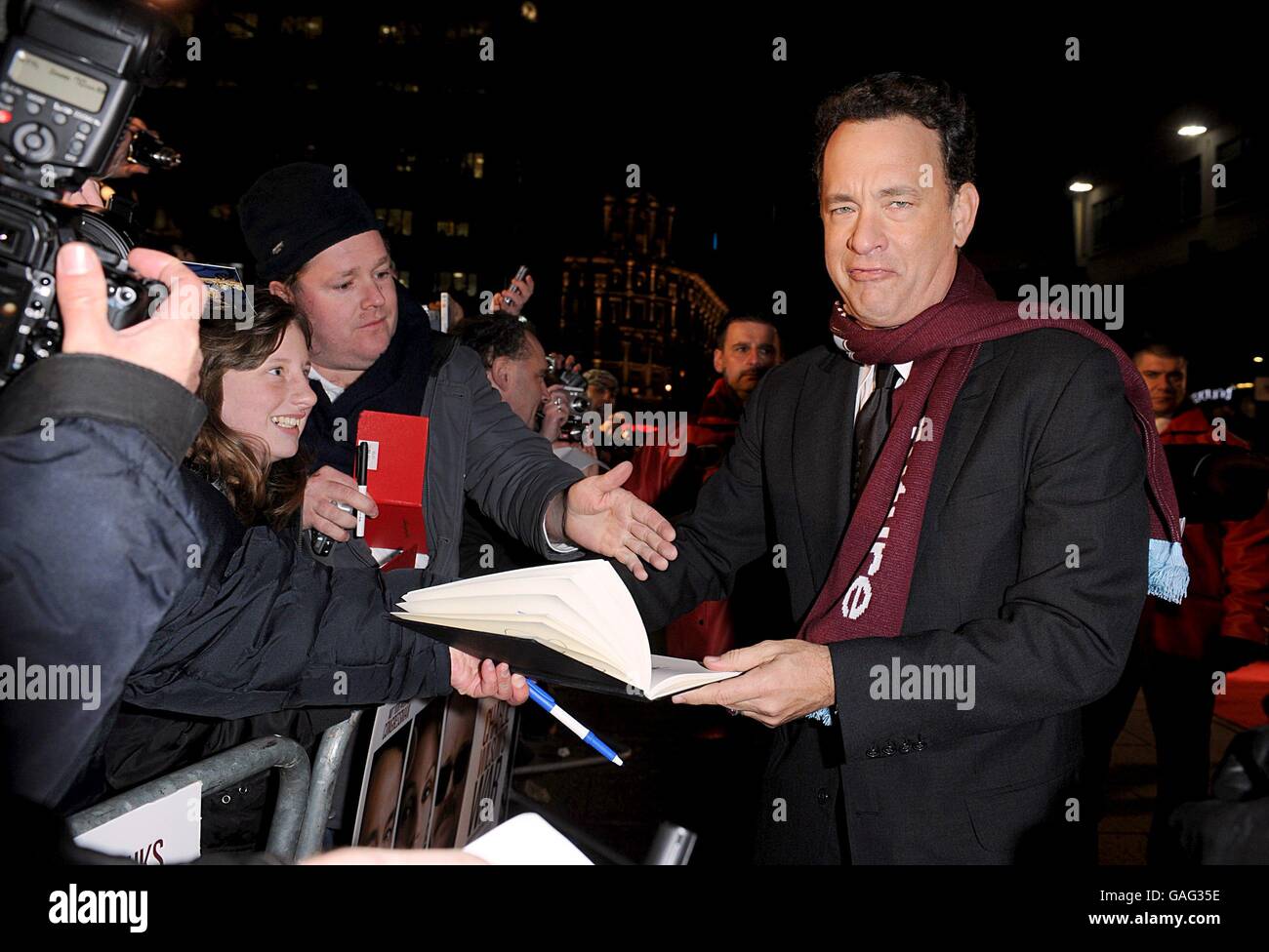 Tom Hanks signs autographs as he arrives for the premiere of Charlie ...