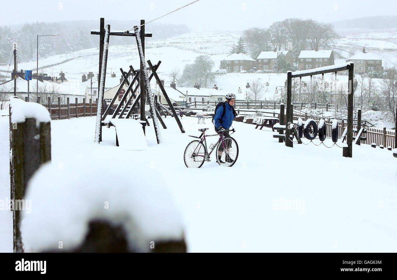 A cyclist pushes her bike through heavy snow in Nenthead on the ...