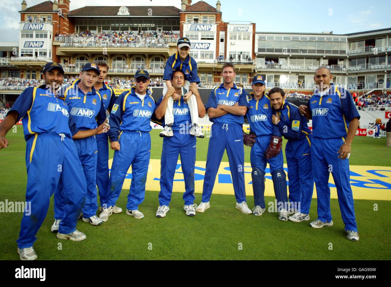 (C) Match mascot Ethan Smith sits on Surrey captain Adam Hollioake's ...