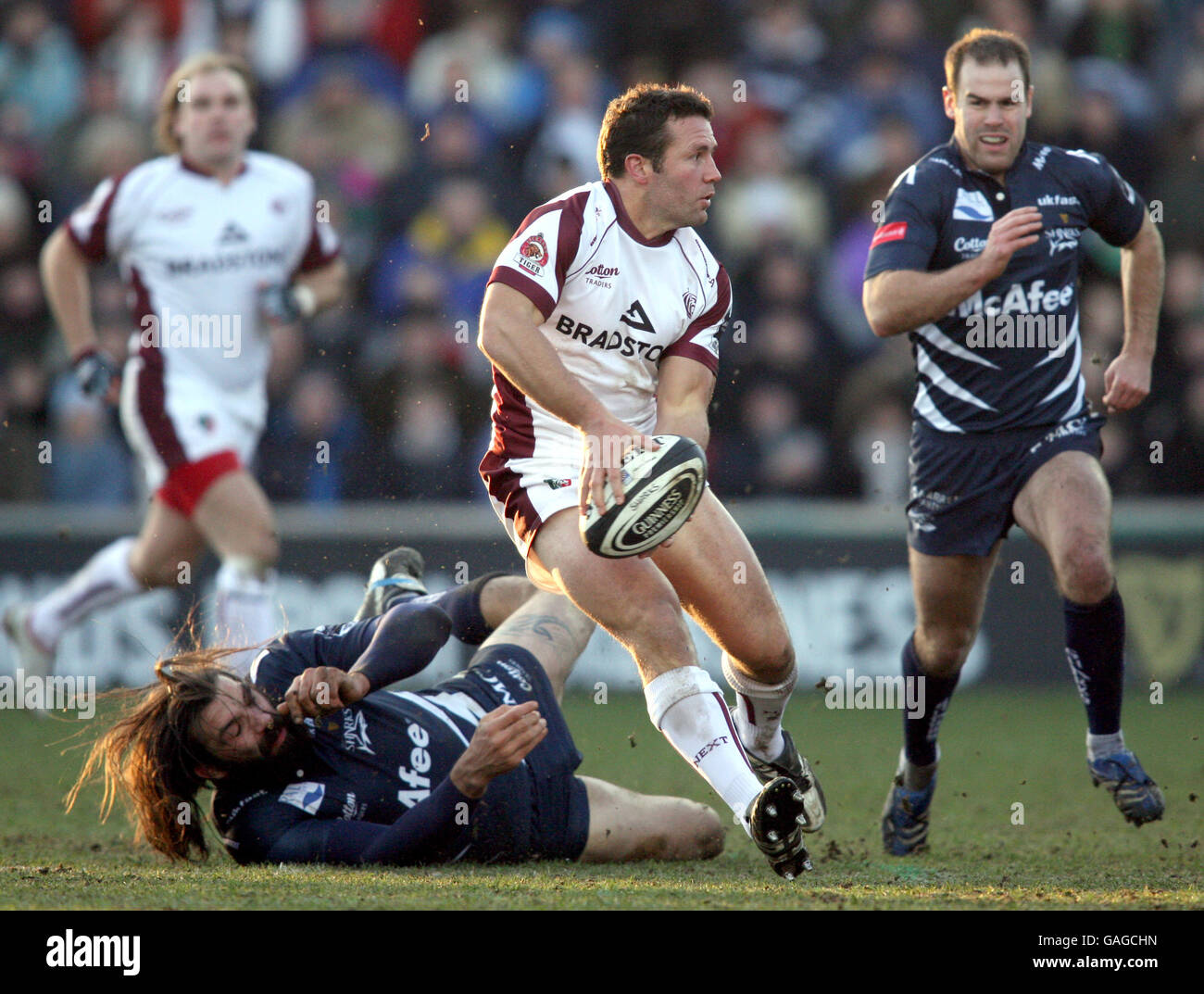 Leicester Tigers' Aaron Mauger evades the tackle from Sale Sharks ...