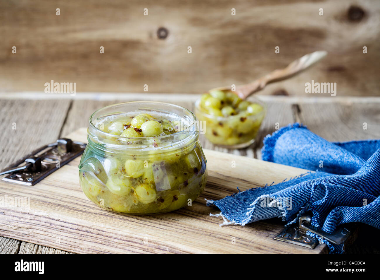 Homemade organic berry jam, gooseberry jelly in glass jar on rustic ...