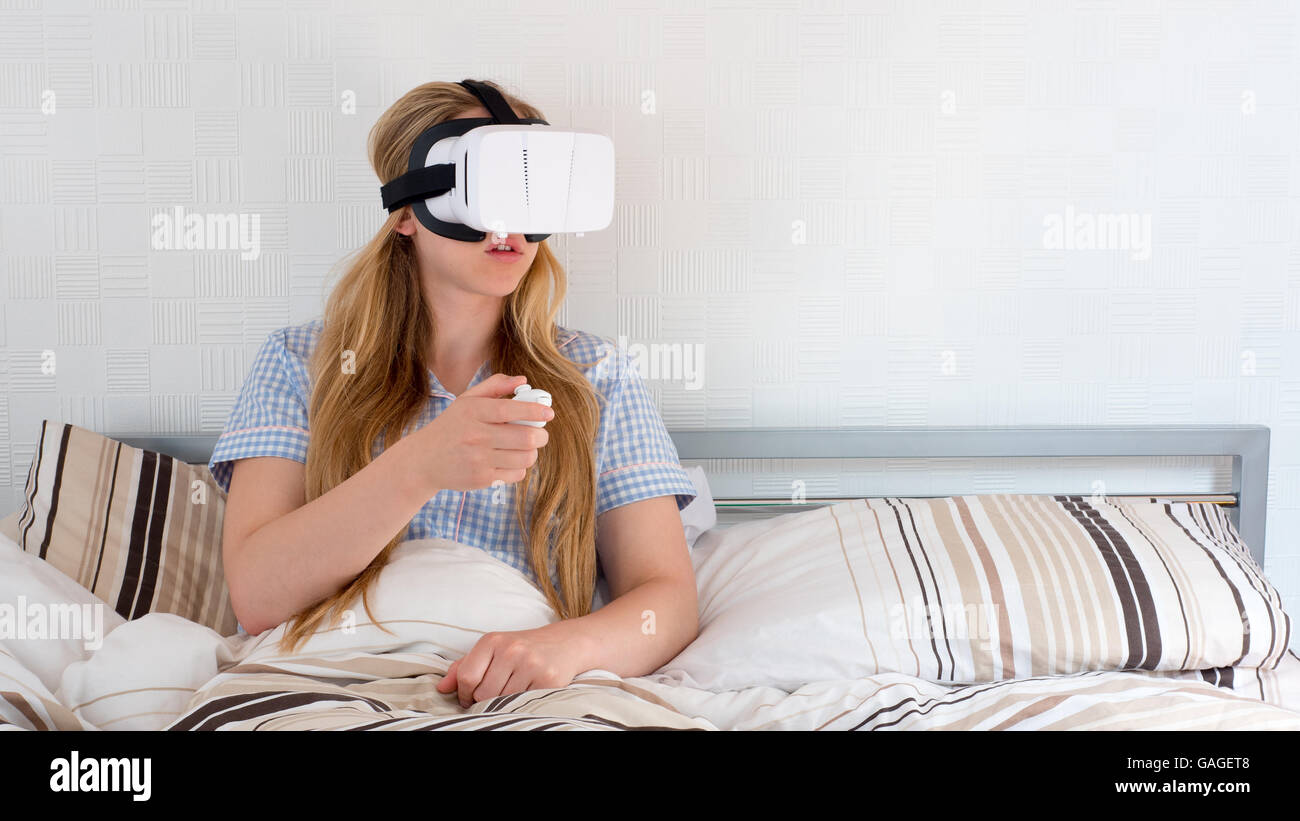 Beautiful woman using VR headset in bed Stock Photo - Alamy
