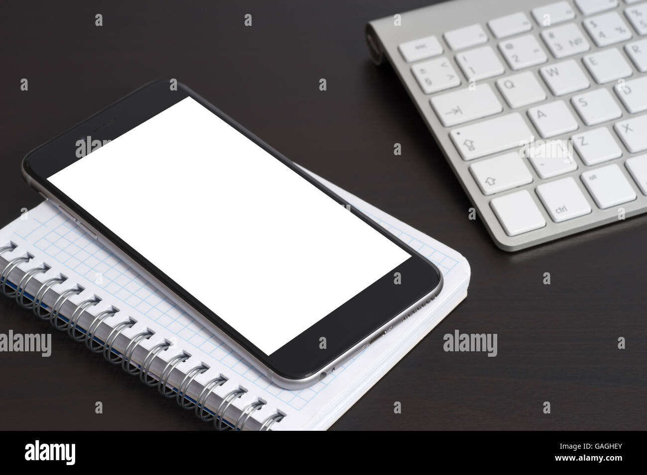 Phone on notepad on dark table and keyboard Stock Photo - Alamy