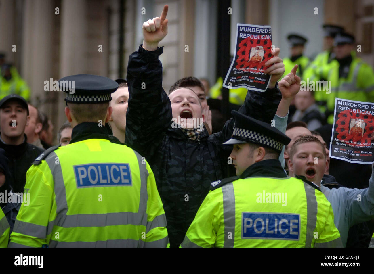Protesters shout and gesture behind rows of police officers at a parade ...