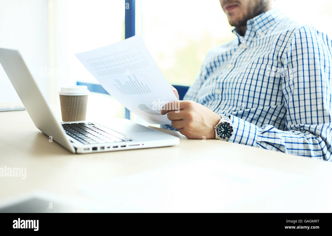 Hardworking young businessman reading documents hi-res stock ...