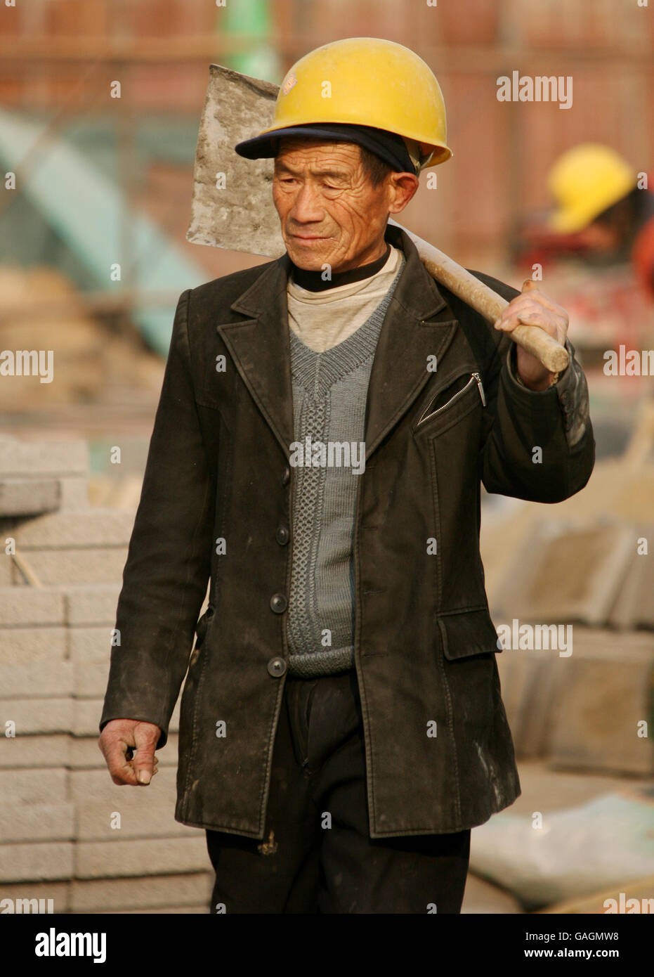 Stock Picture of the a Chinese Man carrying a Shovel as he works on the ...