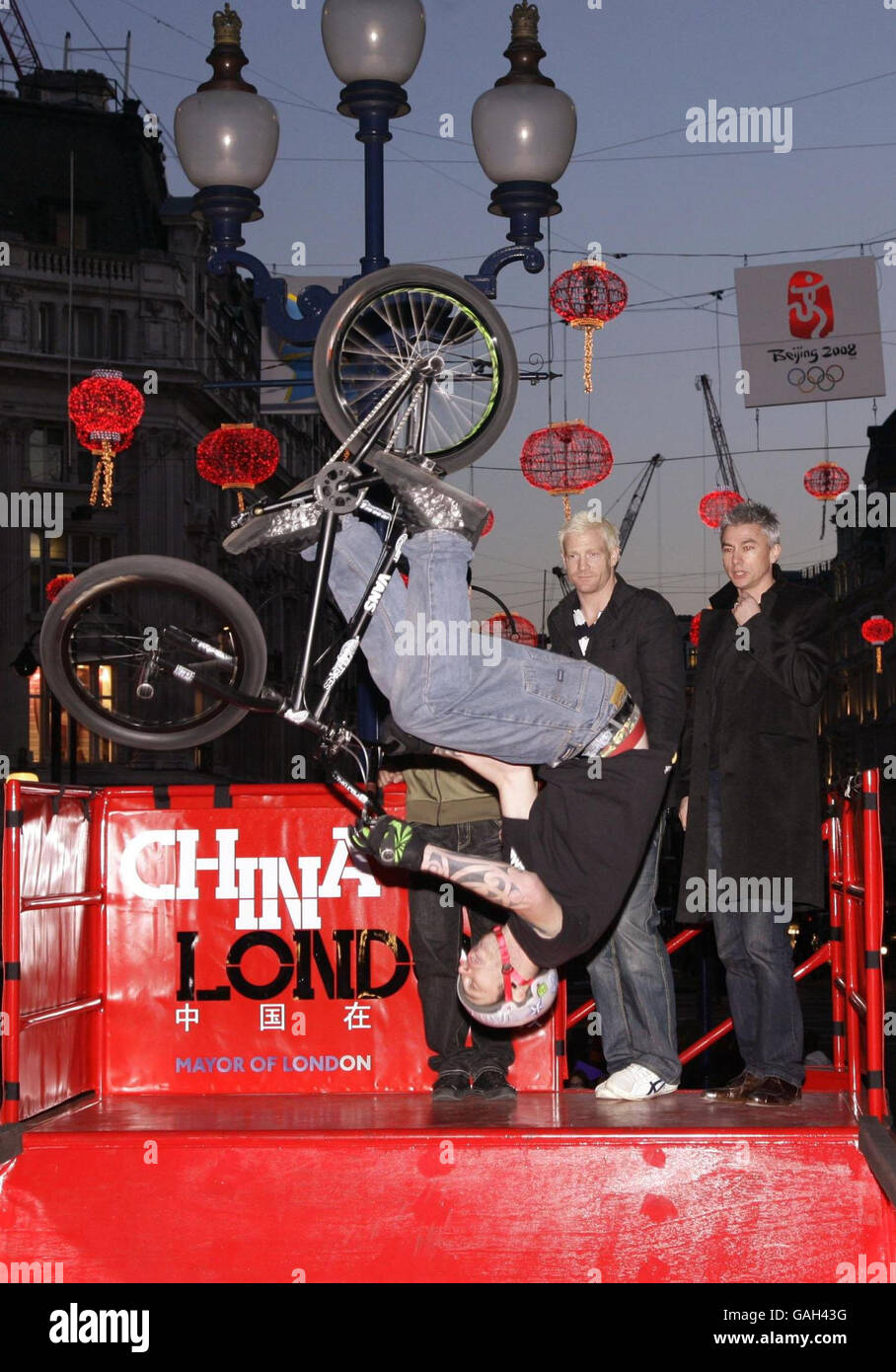 A BMX stunt rider performs on an open top bus, watched by 400m Olympic ...