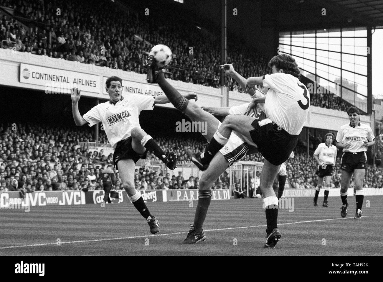 Neil Quinn for Arsenal (centre) shows a leg beating Derby's Ted McMinn ...