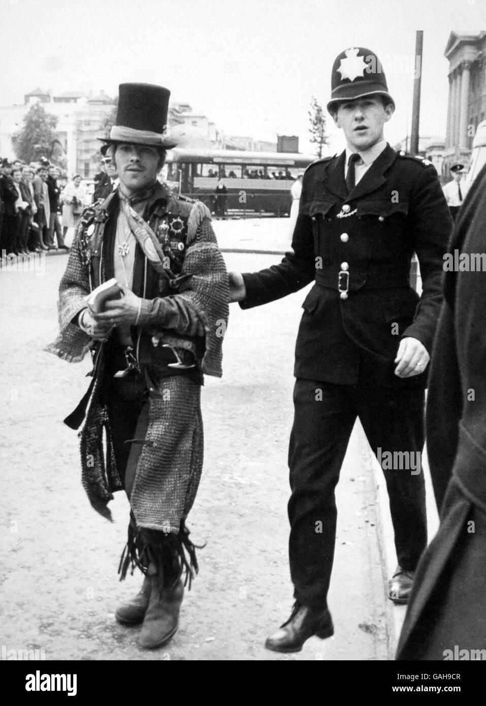 A policeman escorts a top hatted character after the law took over and ...